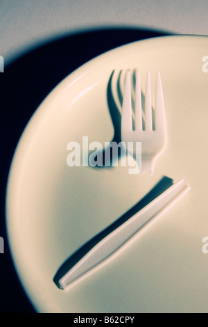 Empty plate with shadows of fork Stock Photo - Alamy