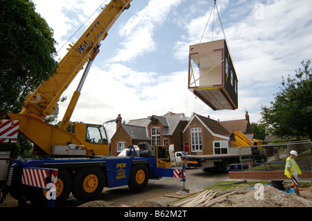 Lifting modular building section off back of a lorry by crane Stock ...