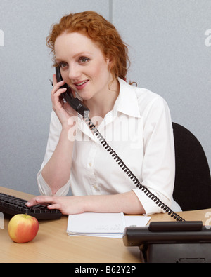 Young redhead woman talking on the phone with open hand doing stop sign ...