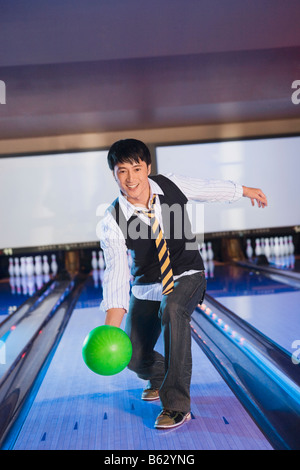 Young man playing ten pin bowling Stock Photo - Alamy