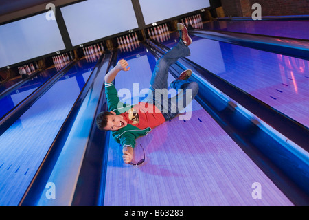 Young man falling in a bowling alley Stock Photo - Alamy