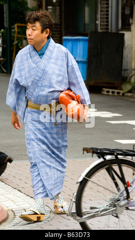 Man wearing geta Japanese wooden shoes under a kimono in Asakusa, Tokyo ...