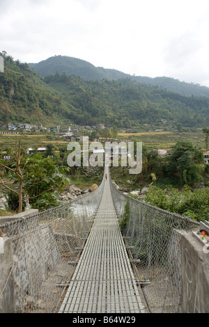 Metal rope bridge crossing the Modi river valley in the Annapurna range ...