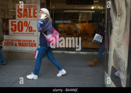 Shoppers pass sale signs in stores in the Herald Square shopping ...