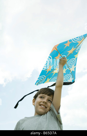 Low angle view of happy boy playing with snow against blue sky in ...