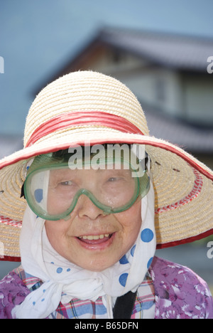 Portrait of an old lady with goggles cutting grass Stock Photo - Alamy