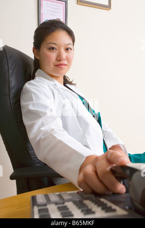 Asian female doctor talk phone call consult patient holding clipboard ...