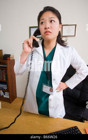 Asian doctor woman talking phone call explaining medical advice patient ...
