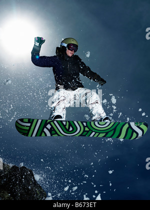young snowboarder woman jumping over the slope in winter Stock Photo ...