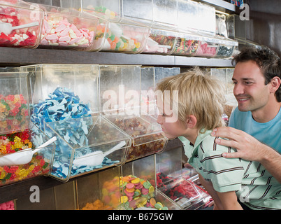 Young man with son choosing sweets at grocery store Stock Photo - Alamy