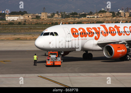 Easyjet Boeing aircraft being pushed out of parking area by airfield ...