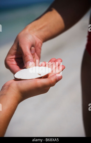 Woman giving girl disc-shaped object, close-up Stock Photo - Alamy