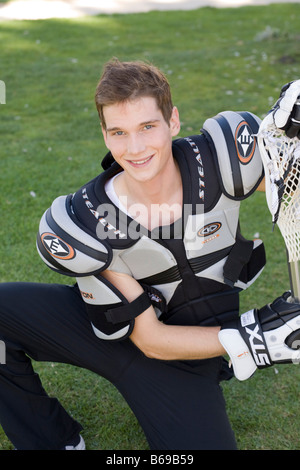 Young man holding lacrosse racket, smiling Stock Photo - Alamy