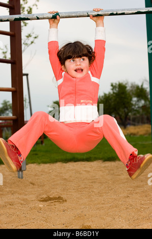 Little female child swaying on swing, having fun at playground ...