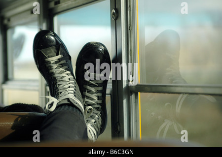 Feet resting on bus seat Stock Photo - Alamy
