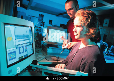 Two young men working at the computer in coworking office. Seen through ...