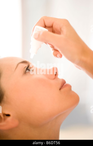 Eye drops. Woman dropping sterile fluid into her eyes Stock Photo - Alamy