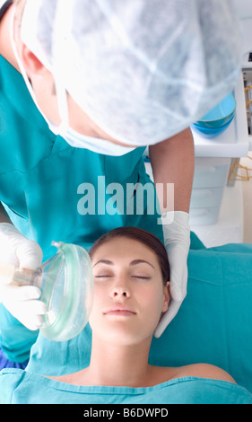 Anaesthesia. Anaesthetist holding a face mask. Anaesthetic gas is ...