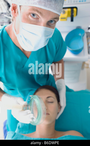 Anaesthesia. Anaesthetist holding a face mask. Anaesthetic gas is ...