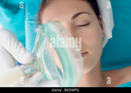 Anaesthesia. Anaesthetist holding a face mask. Anaesthetic gas is ...