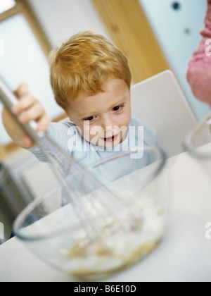 7-year-old boy mixing ingredients for baking a cake. Lifestyle image of ...