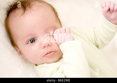 Tired baby rubbing eye and face with hands, sleepy child infant Stock ...