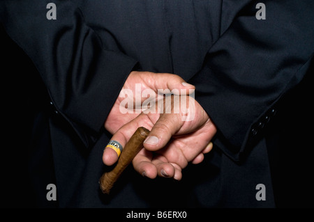 Detail of unrecognizable person with cuban cigar sitting on stairs at ...
