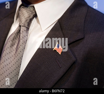 An American flag lapel pin on the collar of a business suit jacket ...