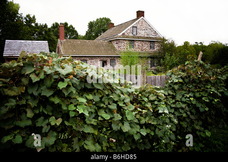 An 18th century colonial American farmstead with various out buildings ...