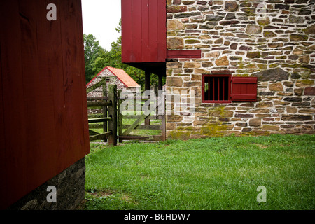 An 18th century colonial American farmstead with various out buildings ...