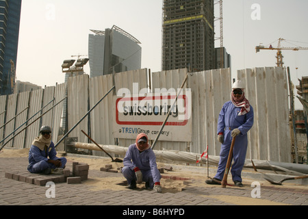 Migrant workers laying bricks for pavement in Doha, Qatar Stock Photo ...