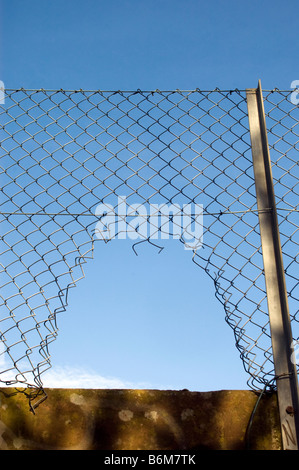 Hole in security fence Stock Photo - Alamy
