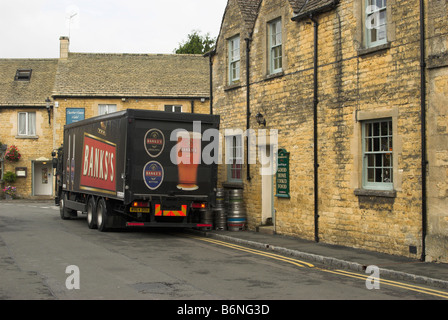 A Brewers dray unloading barrels of beer at a Cotswold pub Stock Photo ...