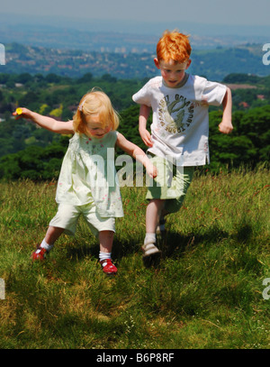 two blond girl running in park Stock Photo - Alamy