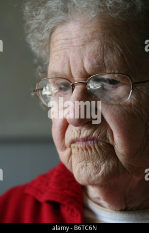 Old lonely woman great-grandmother sitting thoughtfully in summer yard ...