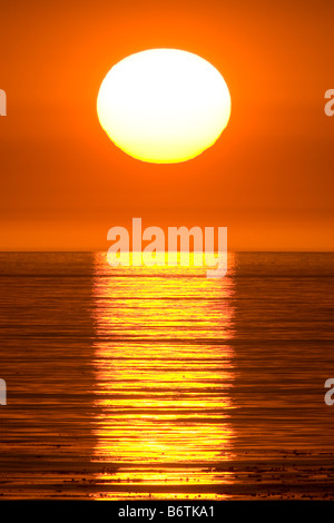 Orange sunset sun shining on sea shore with beautiful white waves ...