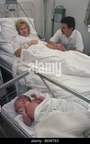 Exhausted mother with newborn baby in delivery room Stock Photo - Alamy