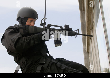 SWAT Team Officer Rappelling and Aiming Gun Stock Photo - Alamy