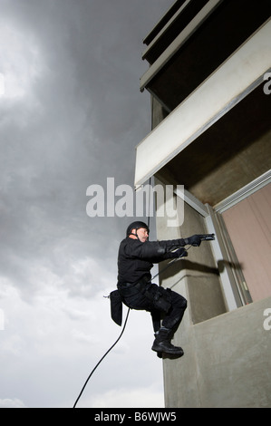 SWAT Team Officer Rappelling and Aiming Gun Stock Photo - Alamy