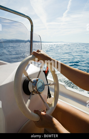 Person driving a boat Stock Photo - Alamy