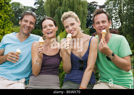 Friends is eating ice creams while they sitting outdoors Stock Photo ...