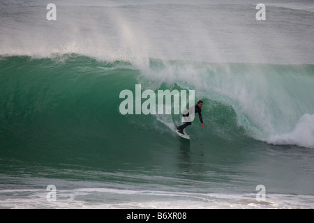Surfer running away from a close out wave at Guincho Beach, Portugal ...