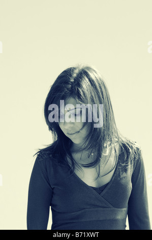 Smiling attractive Muslim female in casual clothes and hijab listening ...