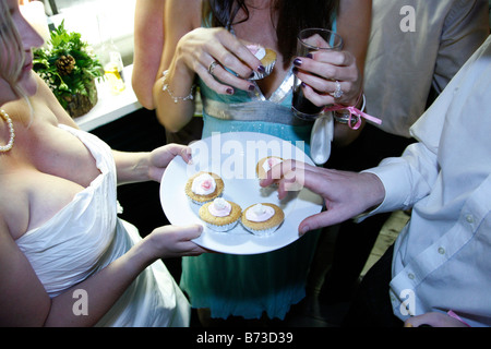 Bride handing wedding cakes to guests at her wedding reception Stock ...