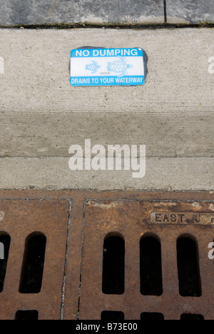 Storm drain with decal warning against pollution dumping Stock Photo ...