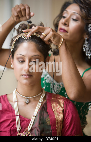 A young Indian mother dressed in a traditional sari holding her young ...