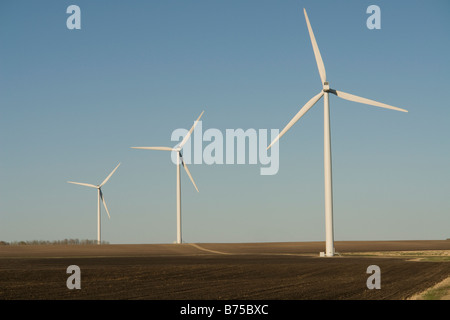 Three wind turbines on the horizon and a road runing through the plains ...