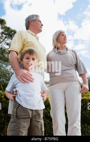 Low angle view of happy boy playing with snow against blue sky in ...