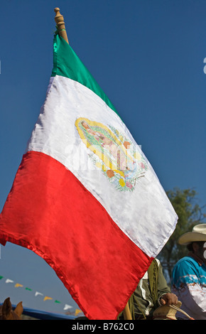 Mexican cowboys ride with a MEXICAN FLAG at the festival of the VIRGIN ...