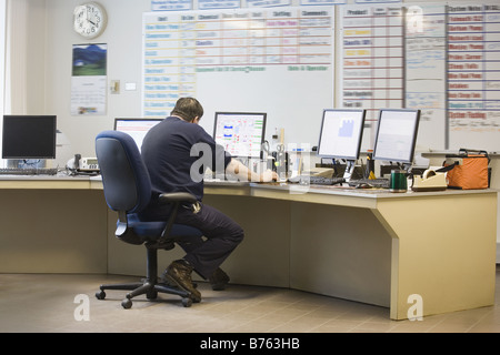 In the Security Control Room Officer Monitors Multiple Screens while ...
